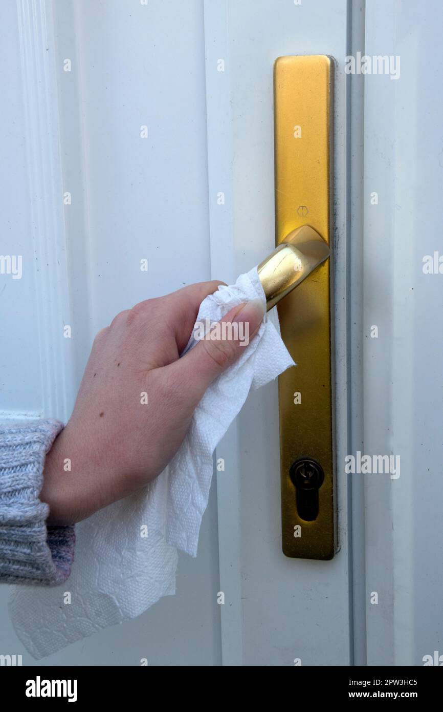 Woman opens door using tissue Stock Photo - Alamy