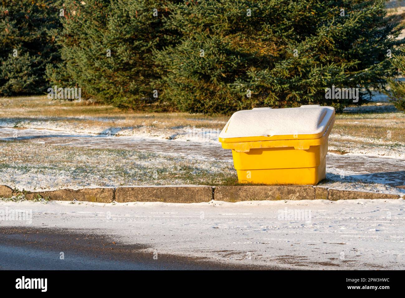 Yellow plastic box with salt or sand on the street for the pedestrian ...