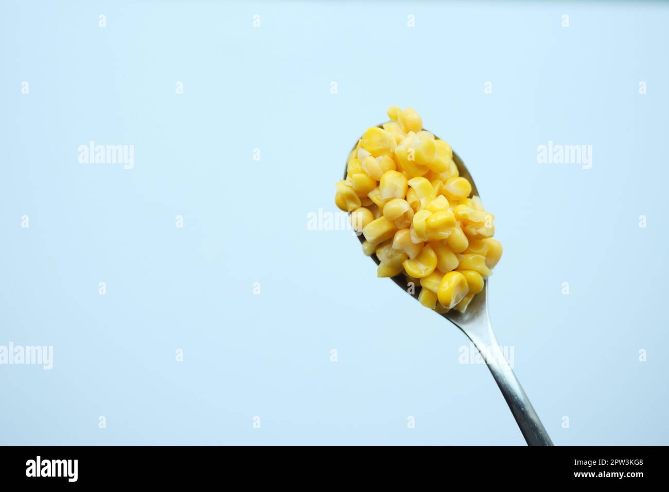 Sweet corns on a spoon isolated on white Stock Photo - Alamy