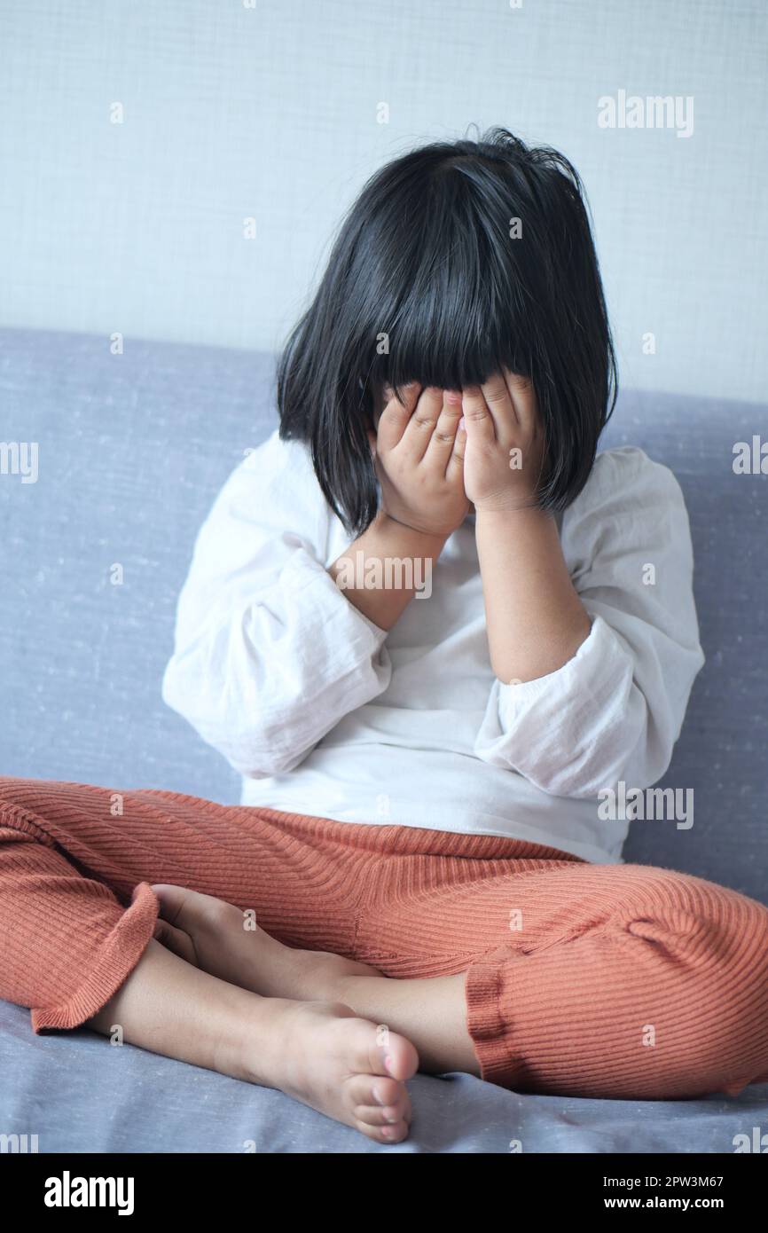 a upset child girl cover her face with hand Stock Photo - Alamy