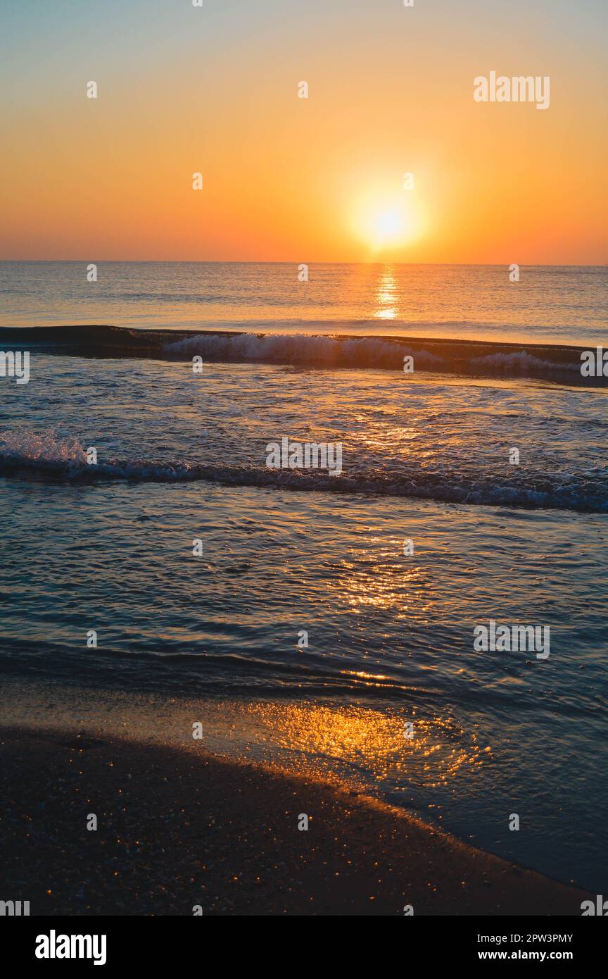 Beautiful summer landscape, sunset at the beach, sparkly sand and waves ...