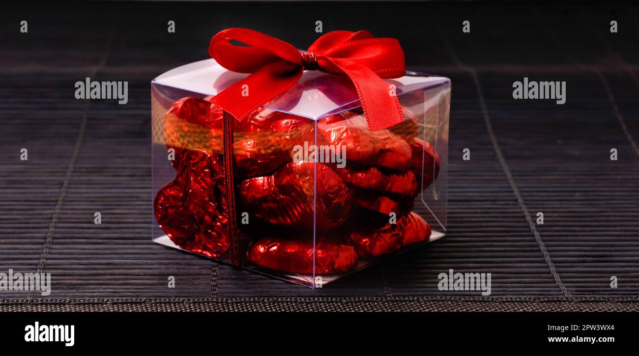 Chocolate in a transparent plastic box with a red bow Stock Photo - Alamy