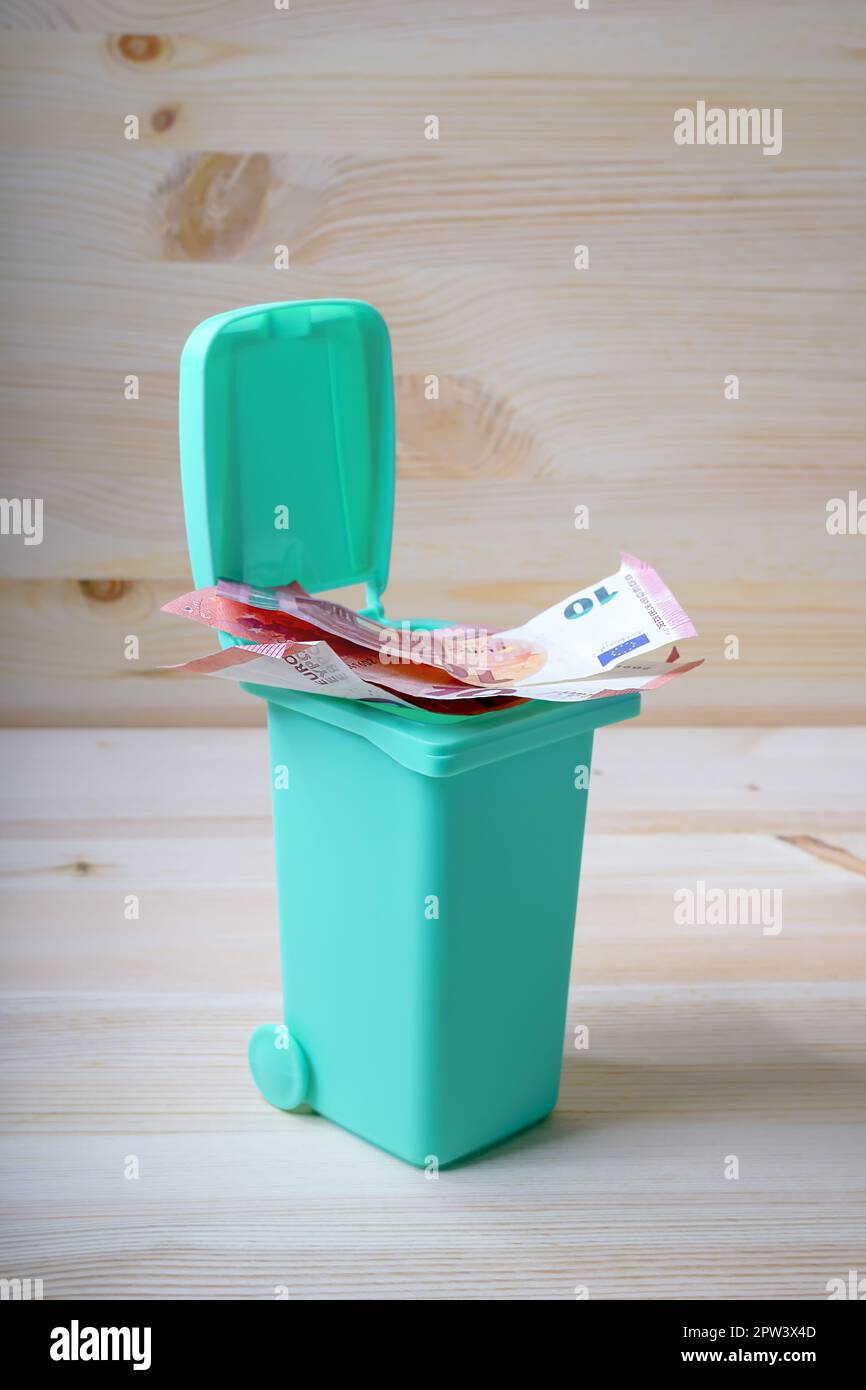 Euro banknote in a garbage can as a symbol for garbage fees, waste of ...