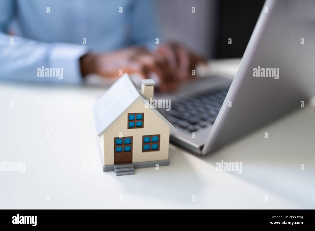 Real Estate House Model Near Laptop On Desk Stock Photo - Alamy