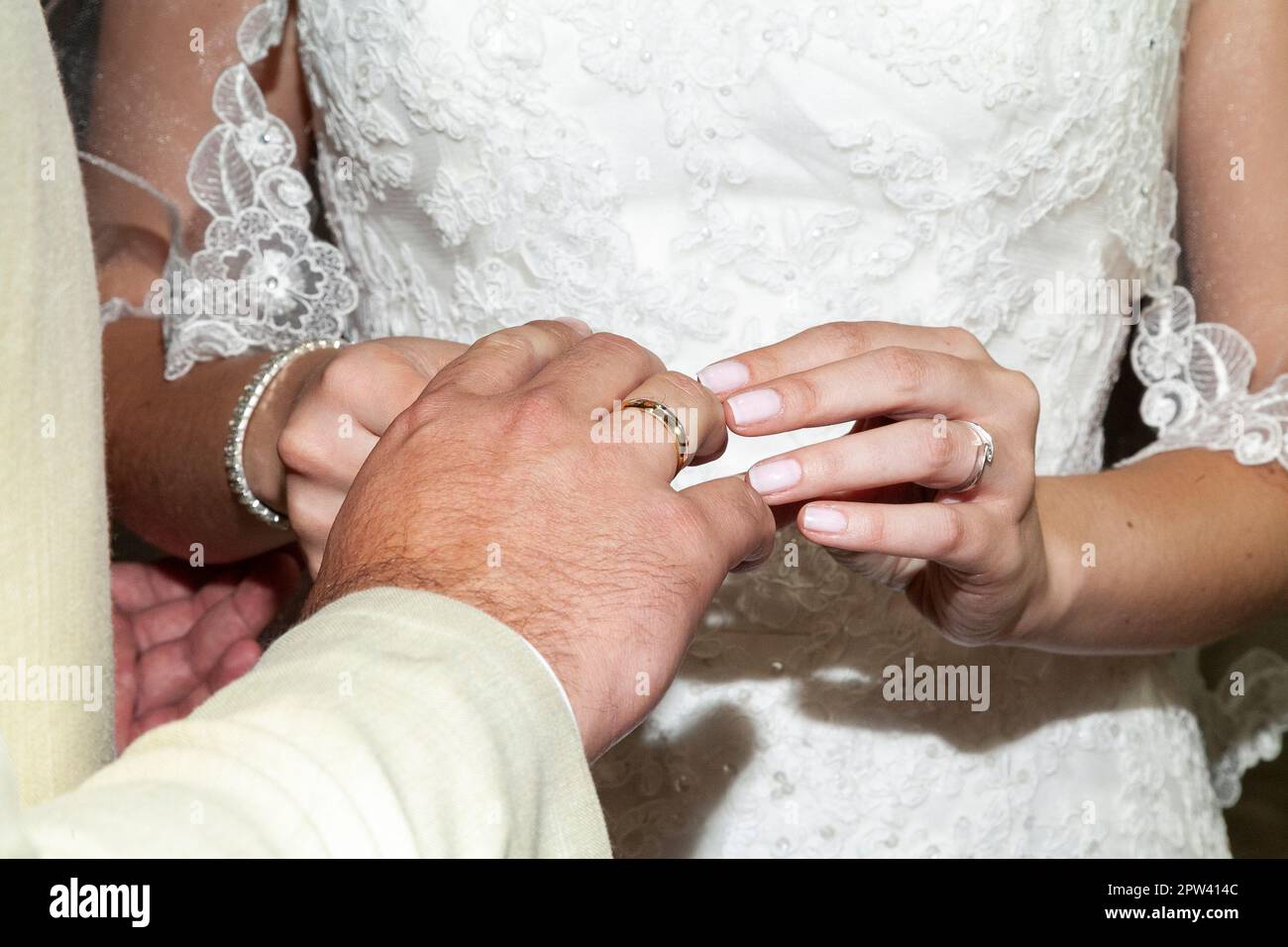 Hands Of The Bride And Groom Placing Wedding Rings Stock Photo - Alamy
