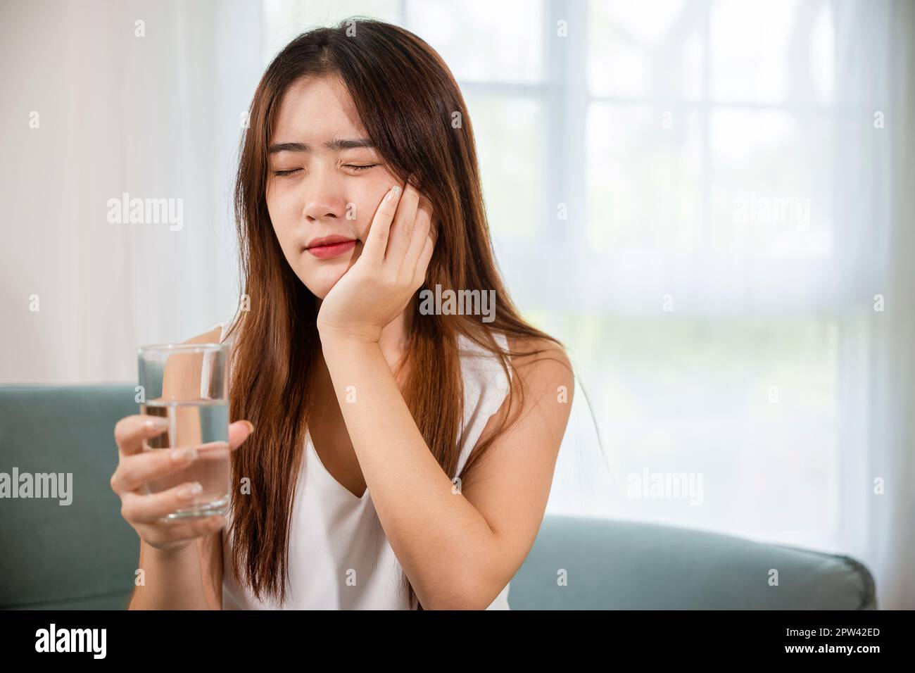 Beautiful female toothache and dental problems touching cheek feeling ...