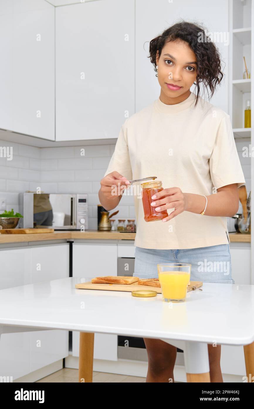 African american woamn holds apricot jam in hand. She is going to make ...