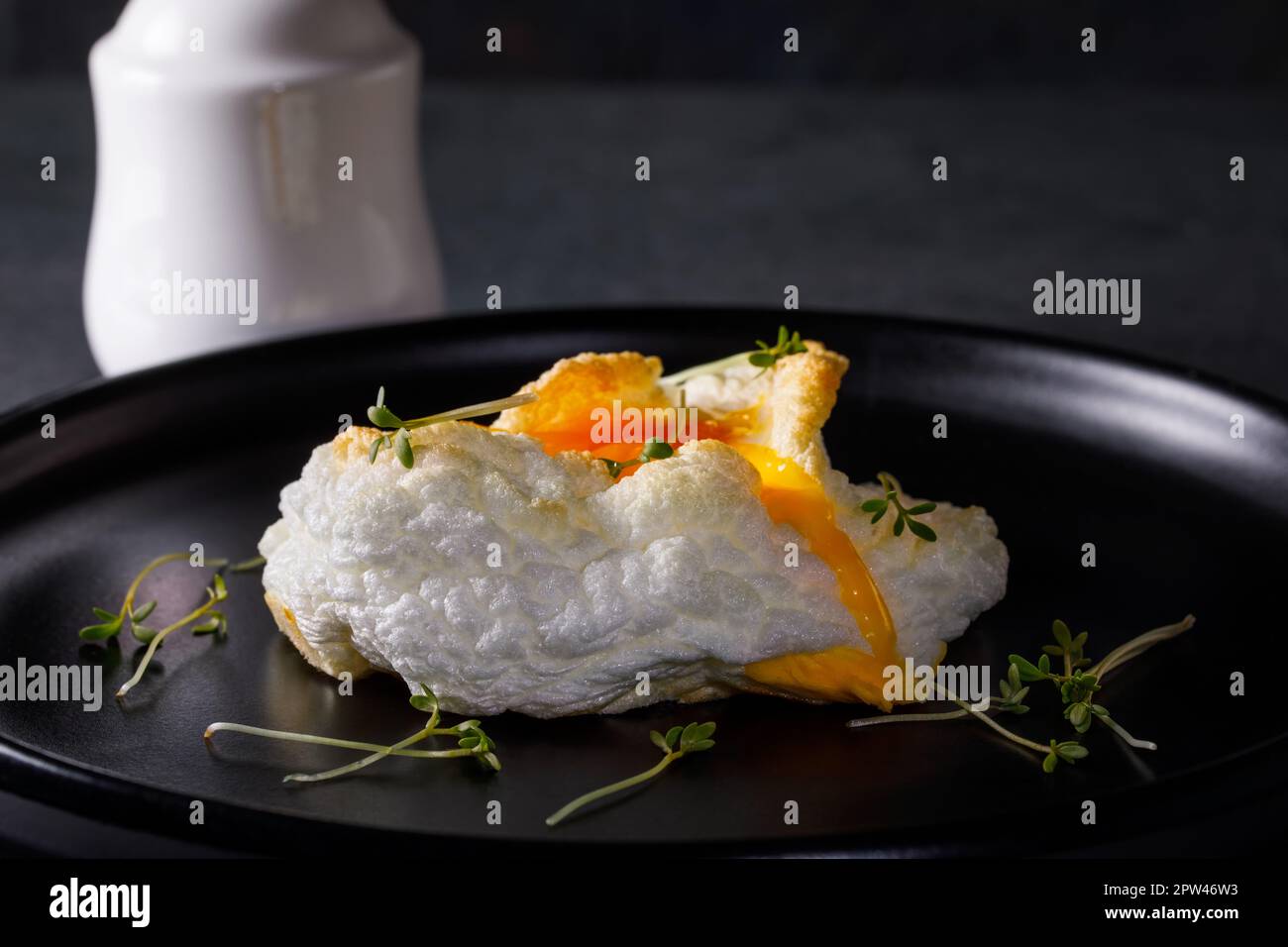 Tender baked egg. Orsini eggs in a cloud. French breakfast on a dark ...