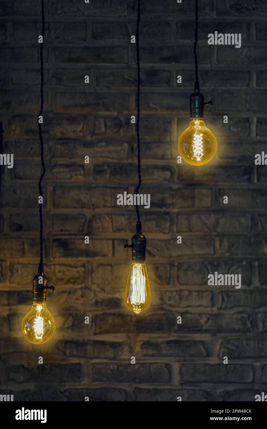 Vintage edison light bulbs on wire with brick wall on background Stock ...