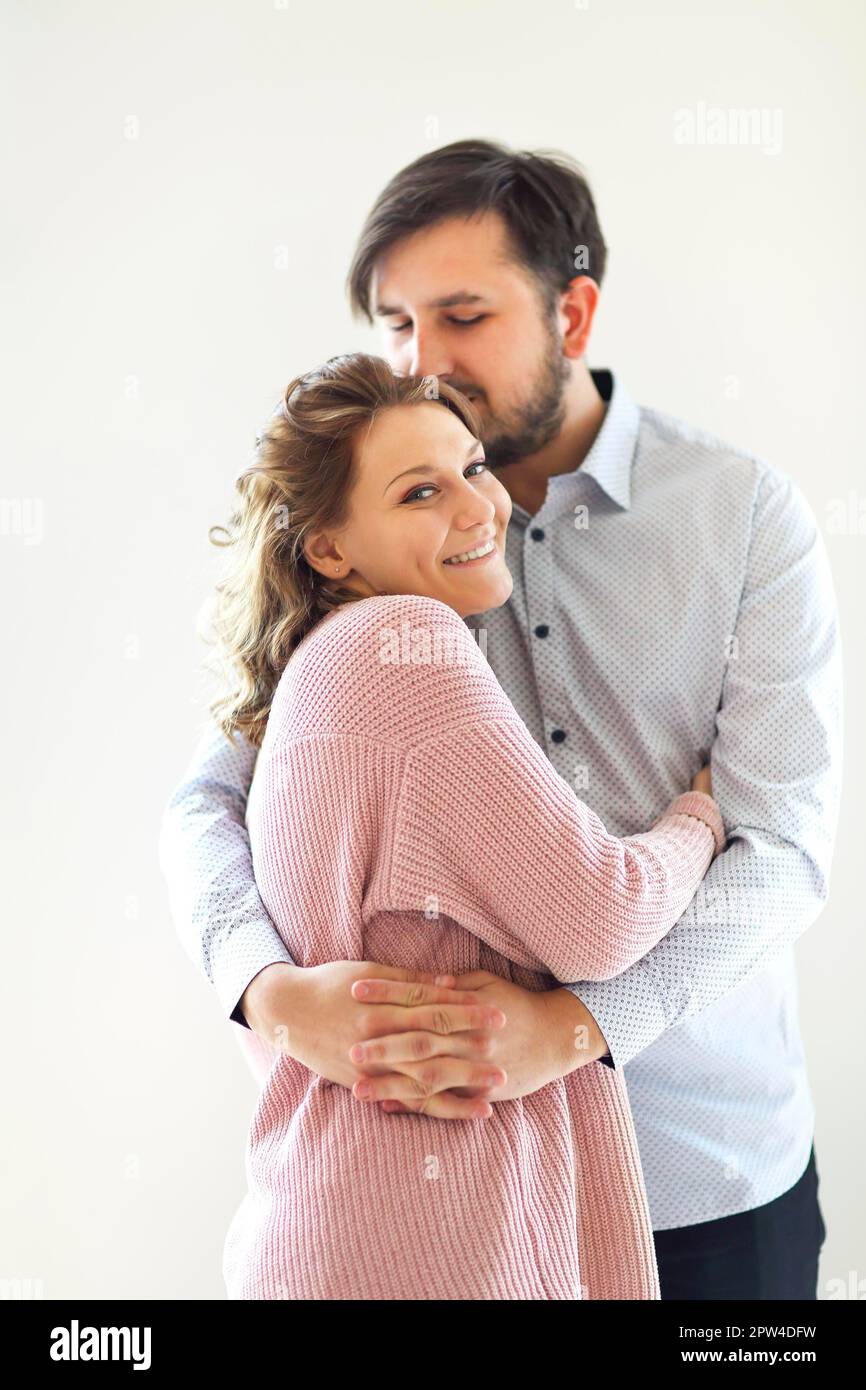 Side view of content loving couple gently embracing on white background ...