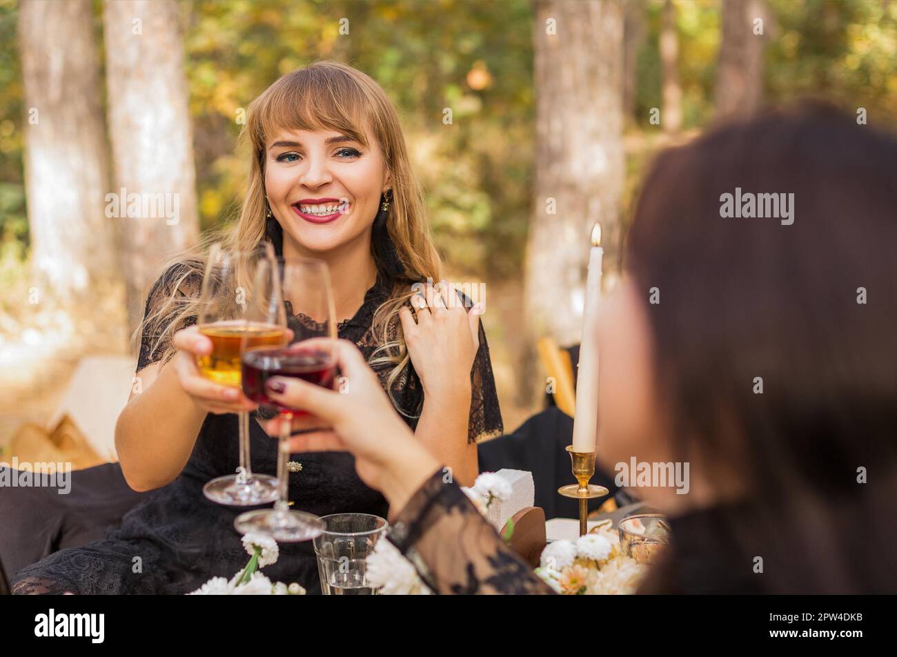 Crop female with glass goblet of friend with red wine during fancy ...