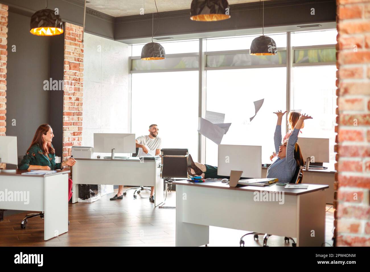 Happy woman throwing papers into air and screaming in excitement near ...