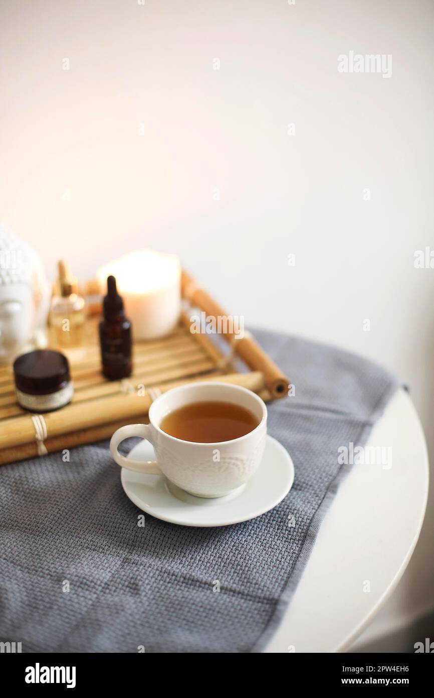 Round table in spa salon with cup of herbal tea next to bamboo tray ...