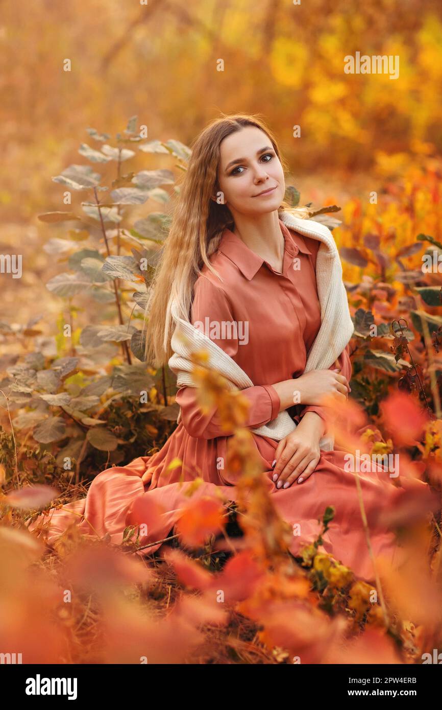 Beautiful young blonde woman wearing boho style long dress while ...