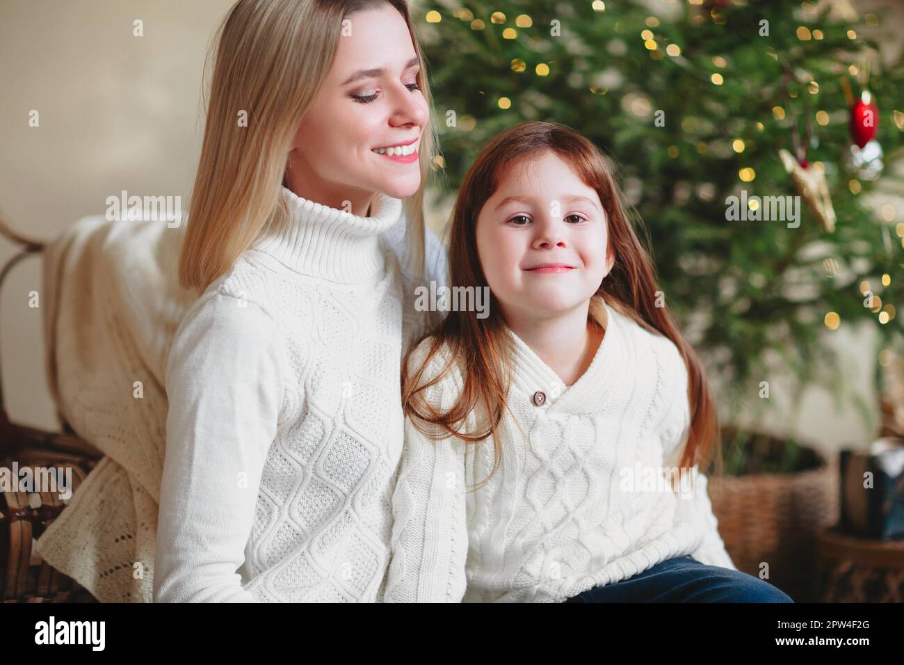 Happy playful little girl daughter playing with positive mother, spending time together during ...