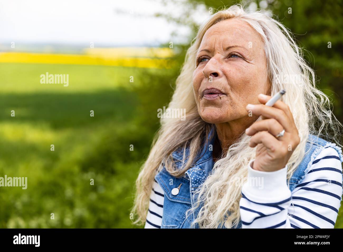 Portrait from a Lady smoking outdoor a cigarette Stock Photo - Alamy