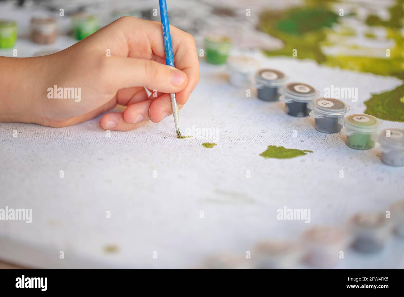 Blurry cropped photo of female hand painting with brush on paper ...