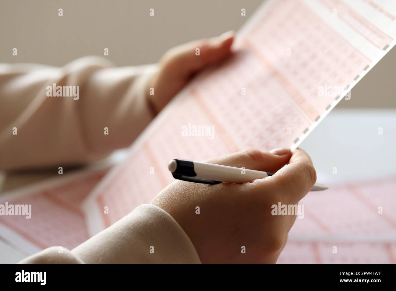 Filling out a lottery ticket. A young woman plays the lottery and ...