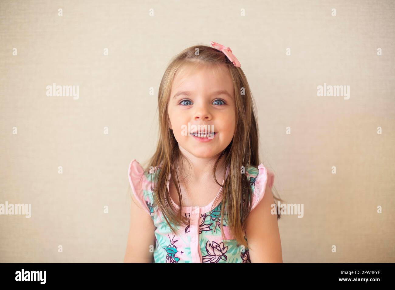 Close up of cute adorable smiling little girl with blue eyes against ...