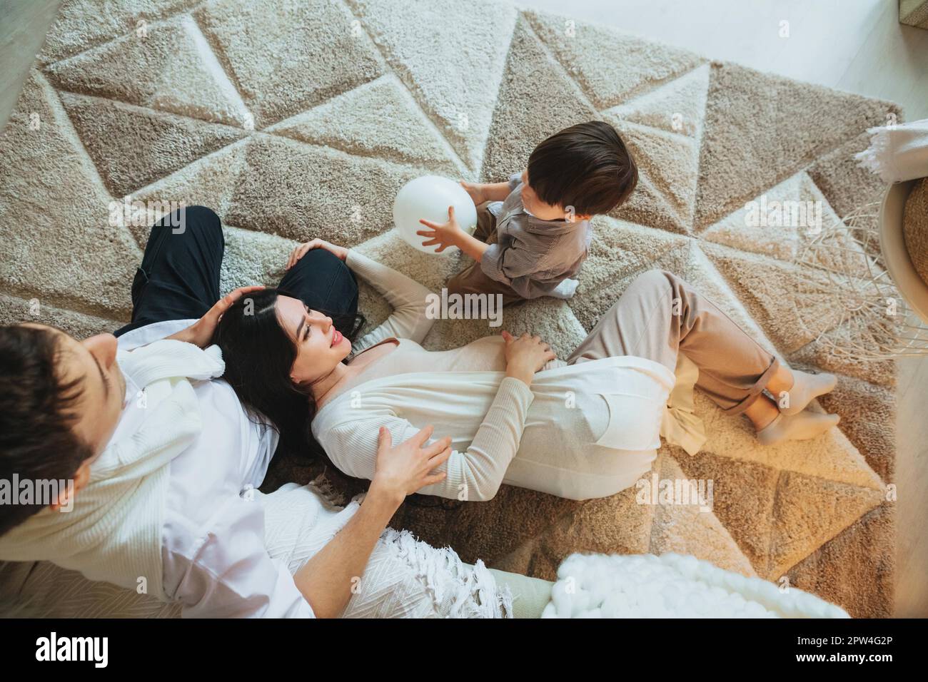 View from above of happy family with small kid expecting new baby ...