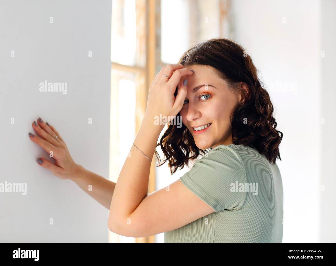 Photo in motion of cheerful young woman, jumping or doing sports indoor ...