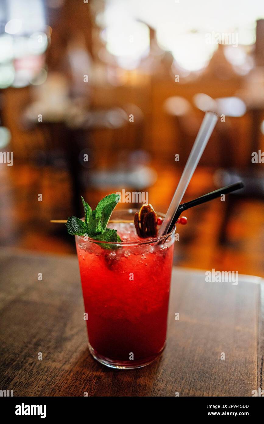 Cold summer red berry drink glass on table in indoor cafe. Alcohol ...