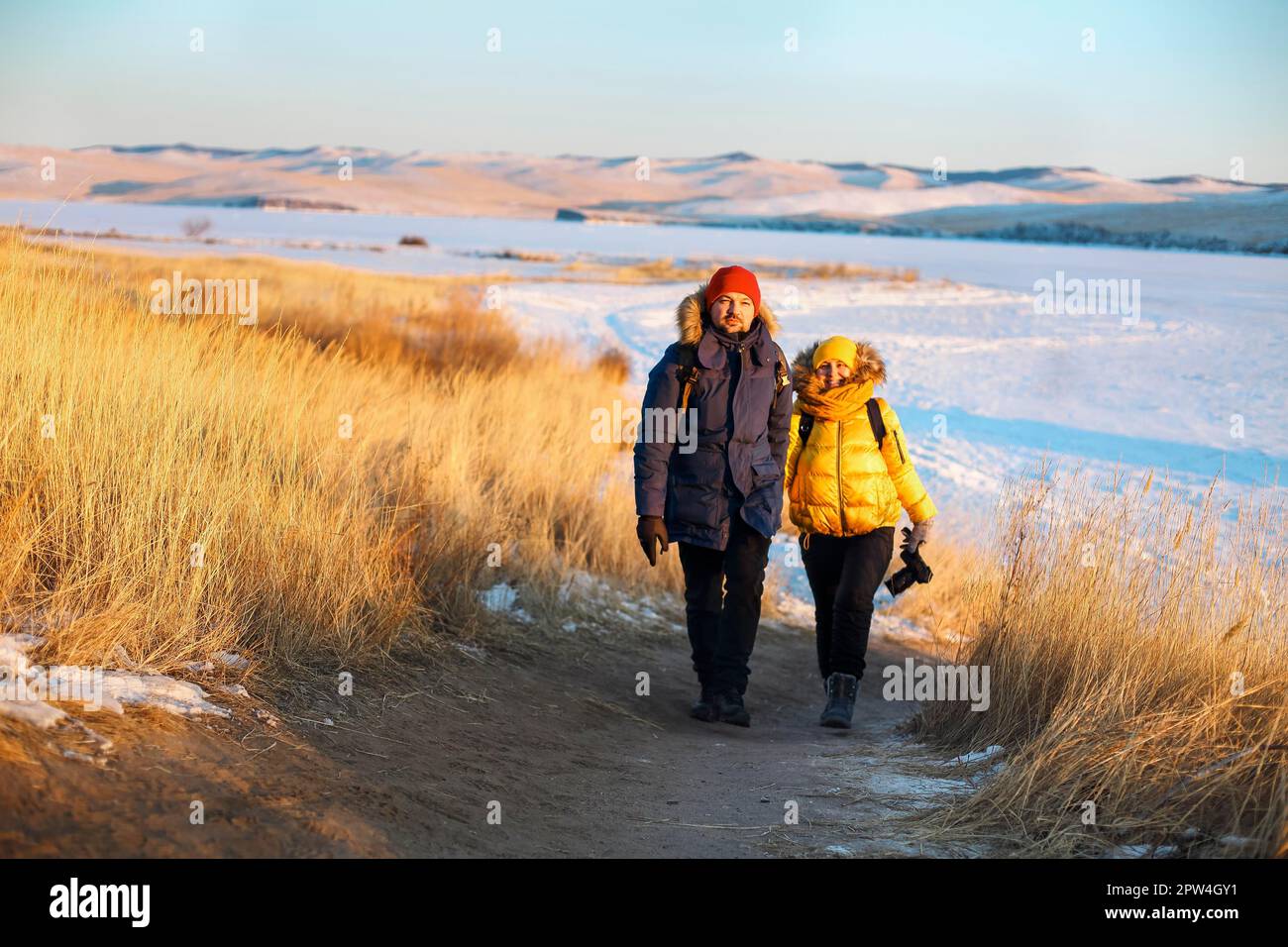 Romantic couple of tourists dressed in warm winter sportswear with ...