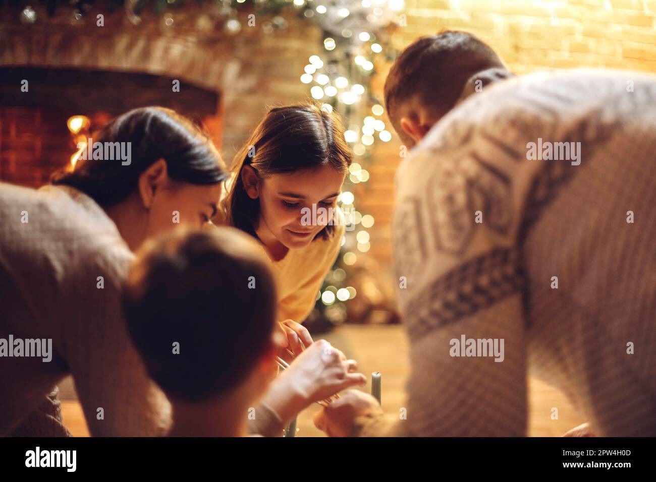 Happy parents with kids enjoying Christmas time at home. Father, mother ...