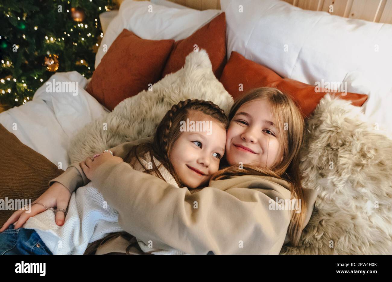 Cozy domestic portrait of two happy smiling little girls sisters ...