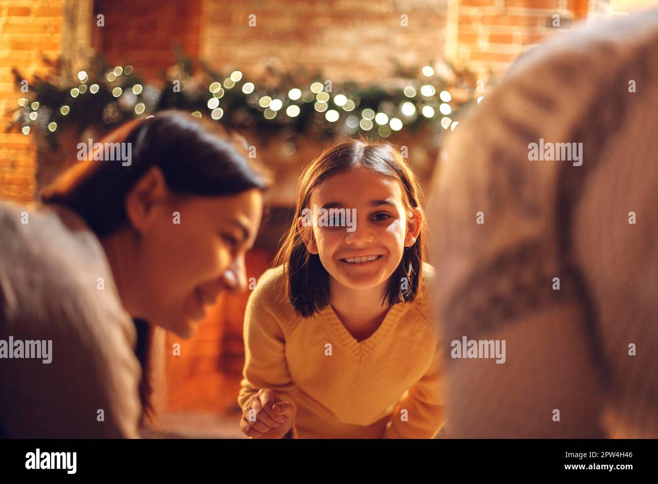 Happy parents with kids enjoying Christmas time at home. Father, mother ...