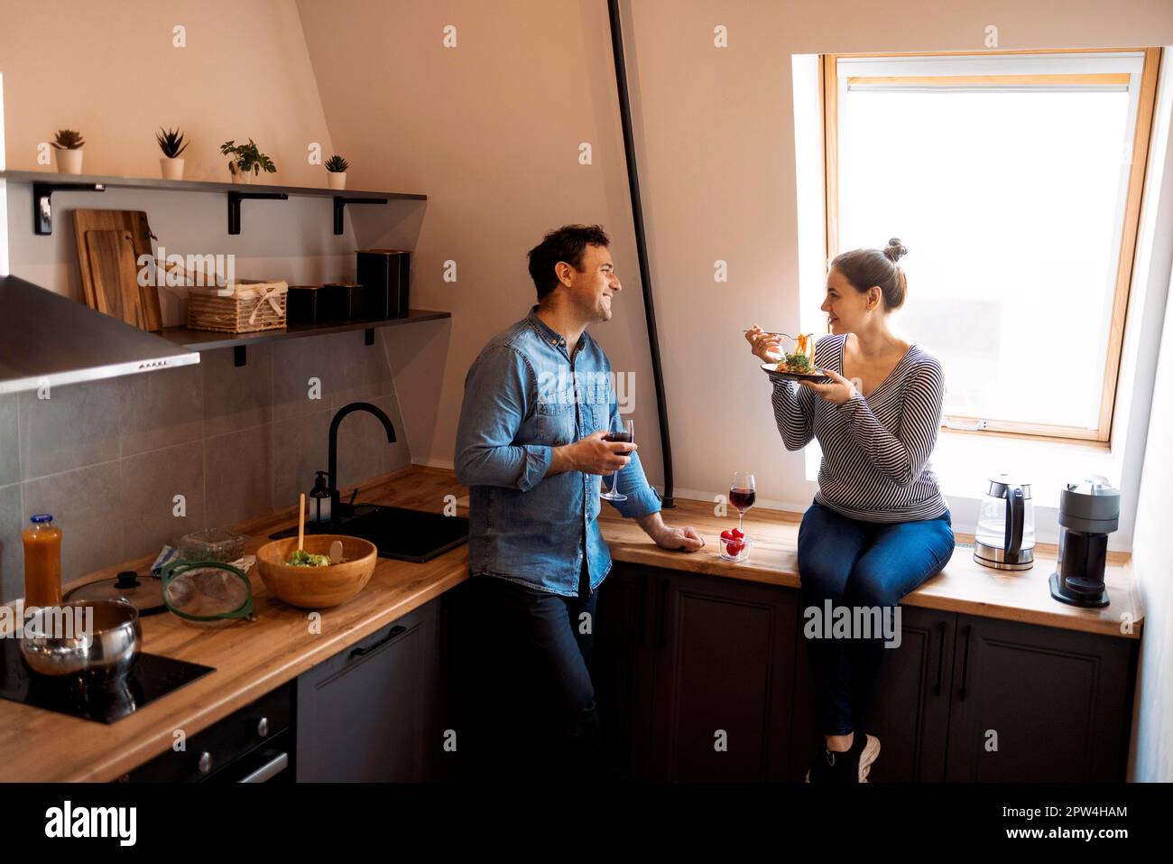 Side view of loving couple eating spaghetti while having romantic ...