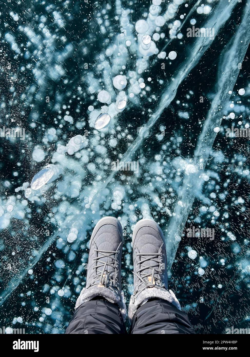 Fragile thin brittle ice underfoot. Female feet on ice. Woman wearing ...