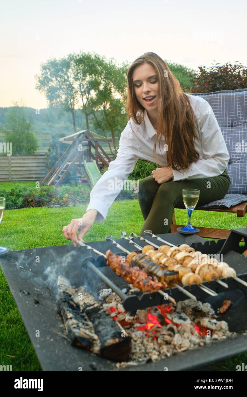 Young woman makes vegetable skewer on barbecue Stock Photo - Alamy
