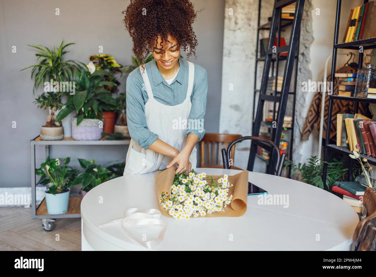 Tender shop assistant enjoying her job while serving bouquet for sale ...