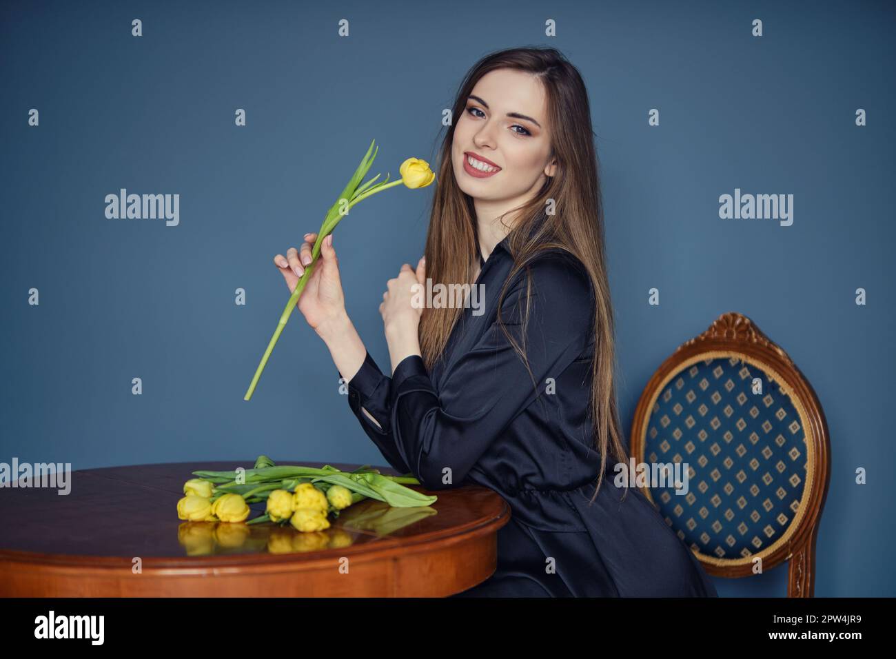 Beautiful young woman sits behind the table in victorian style with ...
