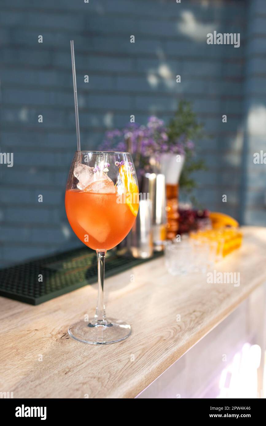 Aperol spritz cocktail in glass with fresh orange and ice on blue ...