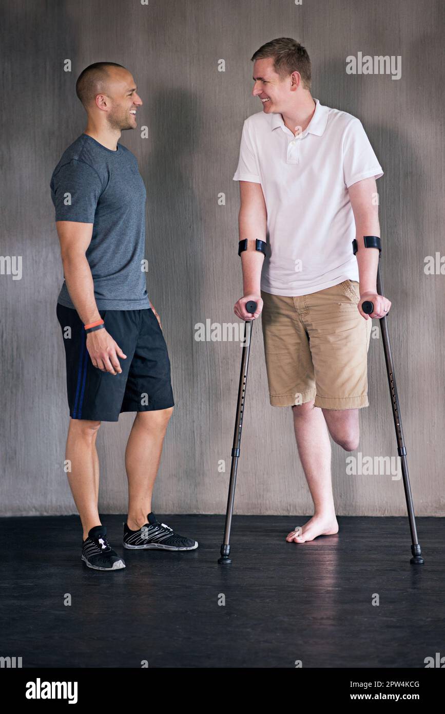 One step at a time. Studio shot of a young amputee training in a gym ...