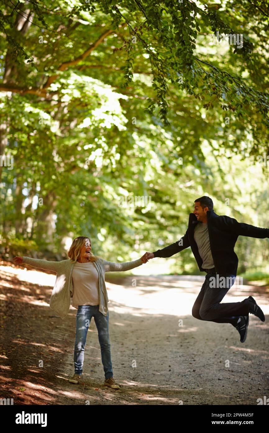 Ecstatic love. a young man jumping for joy while walking with his ...