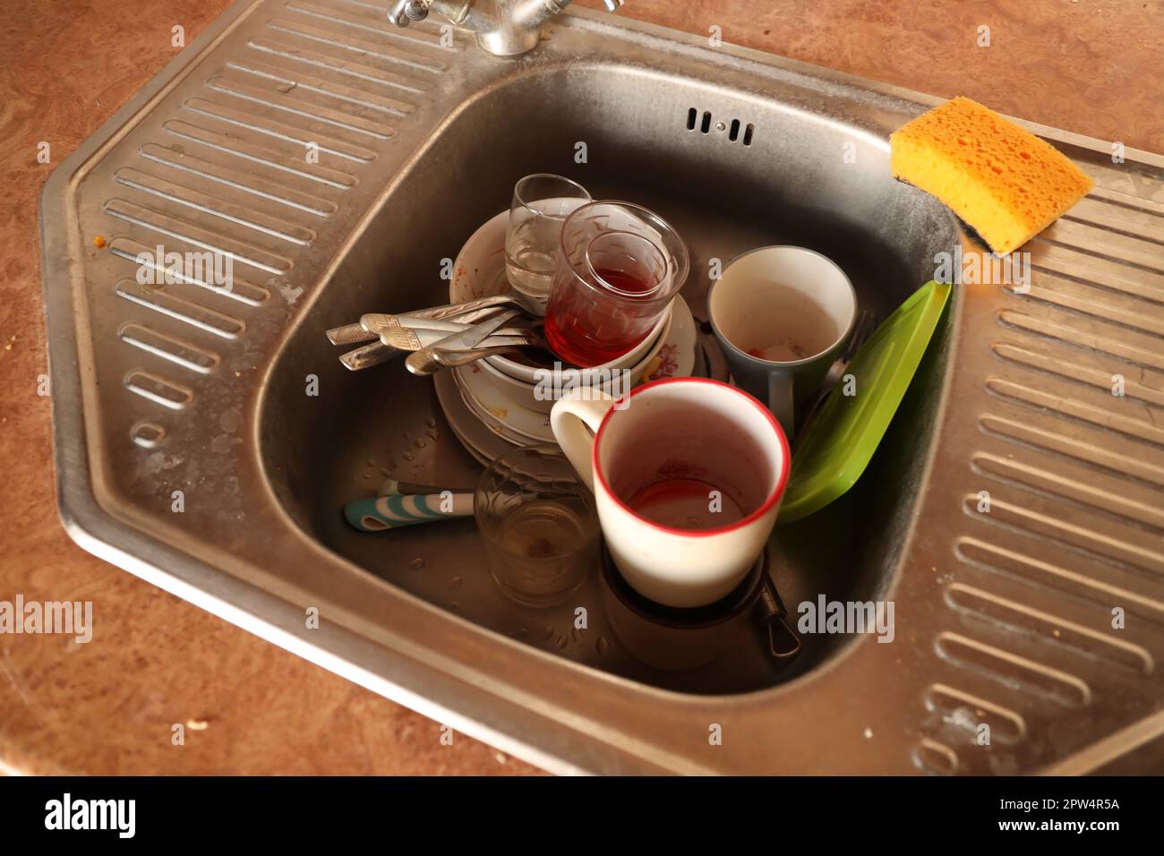 Stack of dirty dishes with food leftovers in the kitchen sink. Unwashed ...