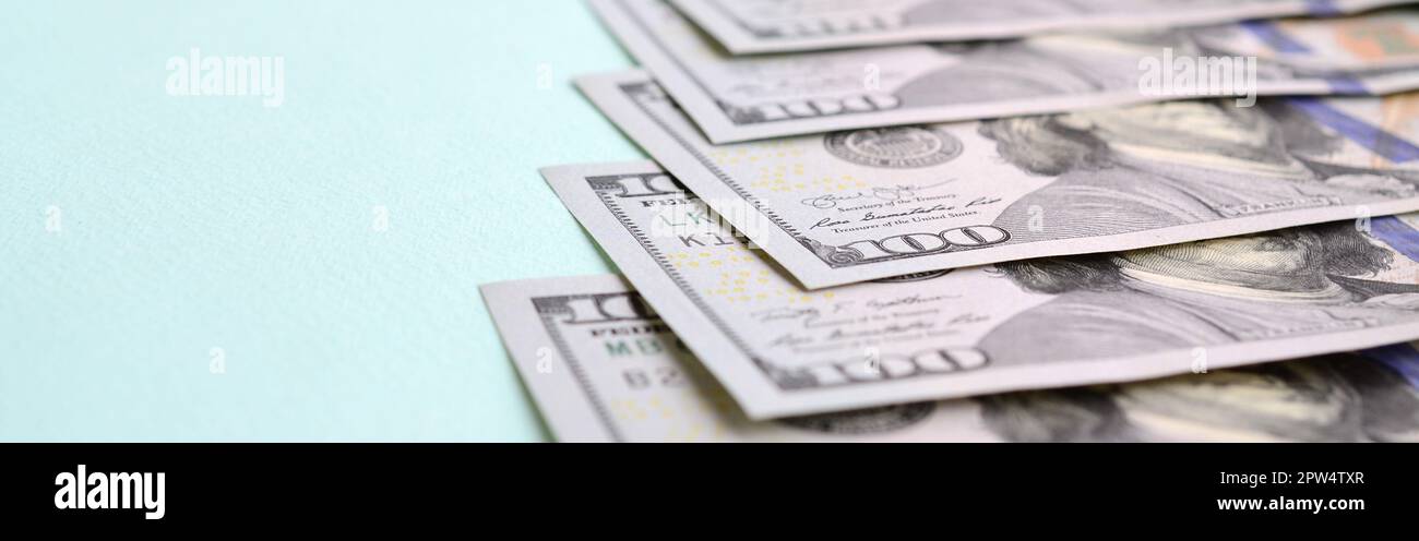 Row of a US dollar bills of a new design lies on a light blue ...