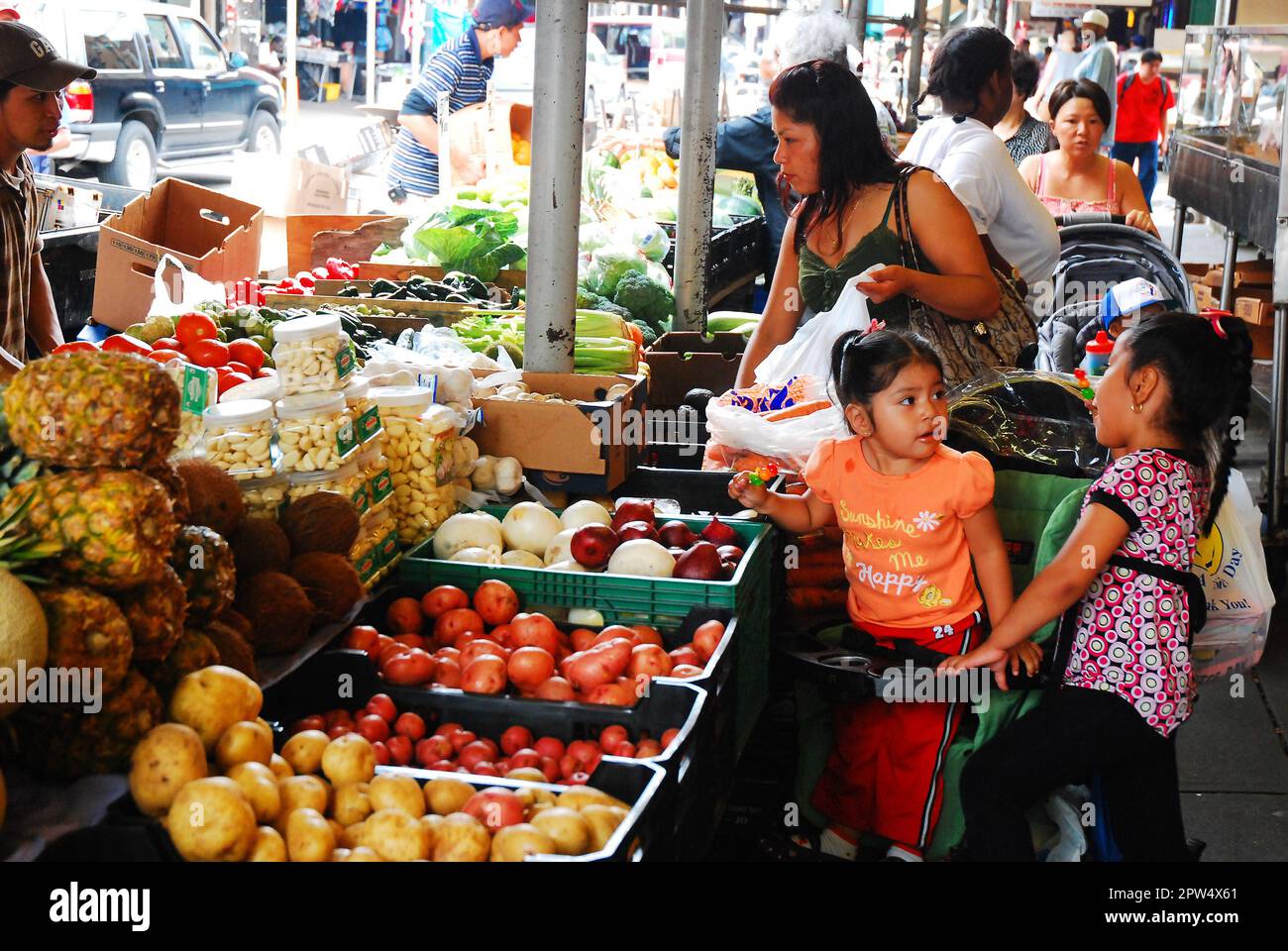 A mother with her two children shops and picks out the best fruits and ...