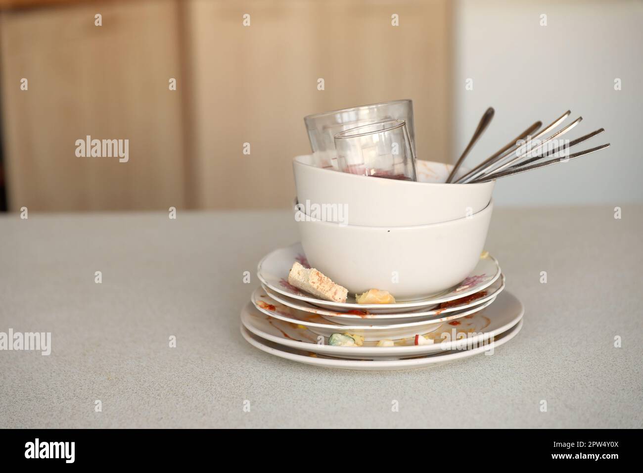 Stack of dirty dishes with food leftovers on the table after meal ...