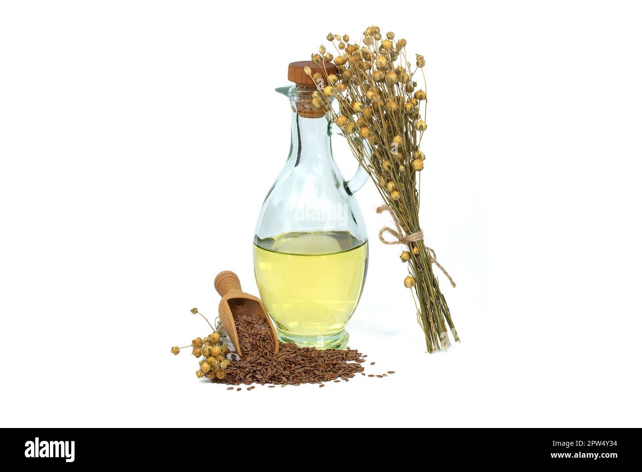 Linseed oil in glass decanter and linseed in wooden scoop near bunch of flax plants isolated on ...