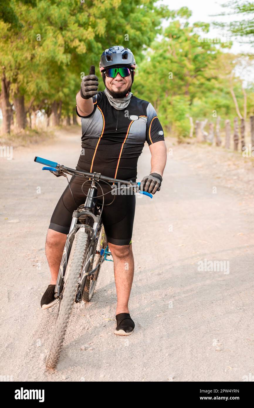 Cyclist giving thumbs up on a road. Professional cyclist doing ok ...