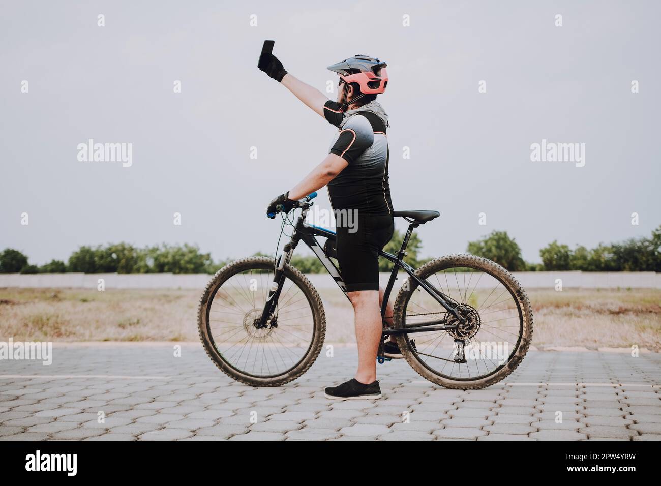 Cyclist taking a selfie on his bike. Chubby cyclist in a sports suit ...