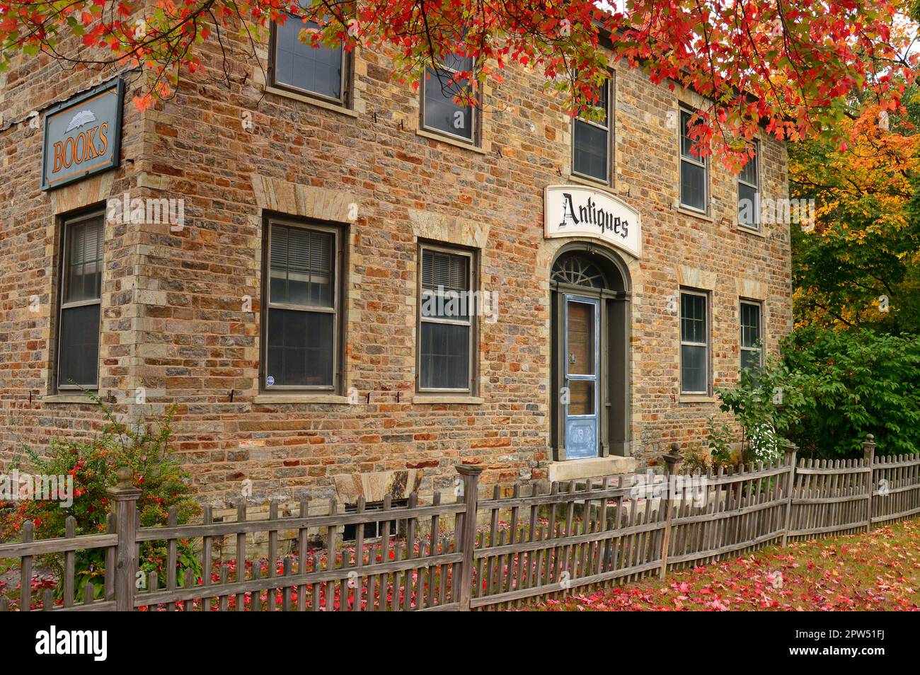 Fall foliage frames a beautiful stone building that houses an antique ...