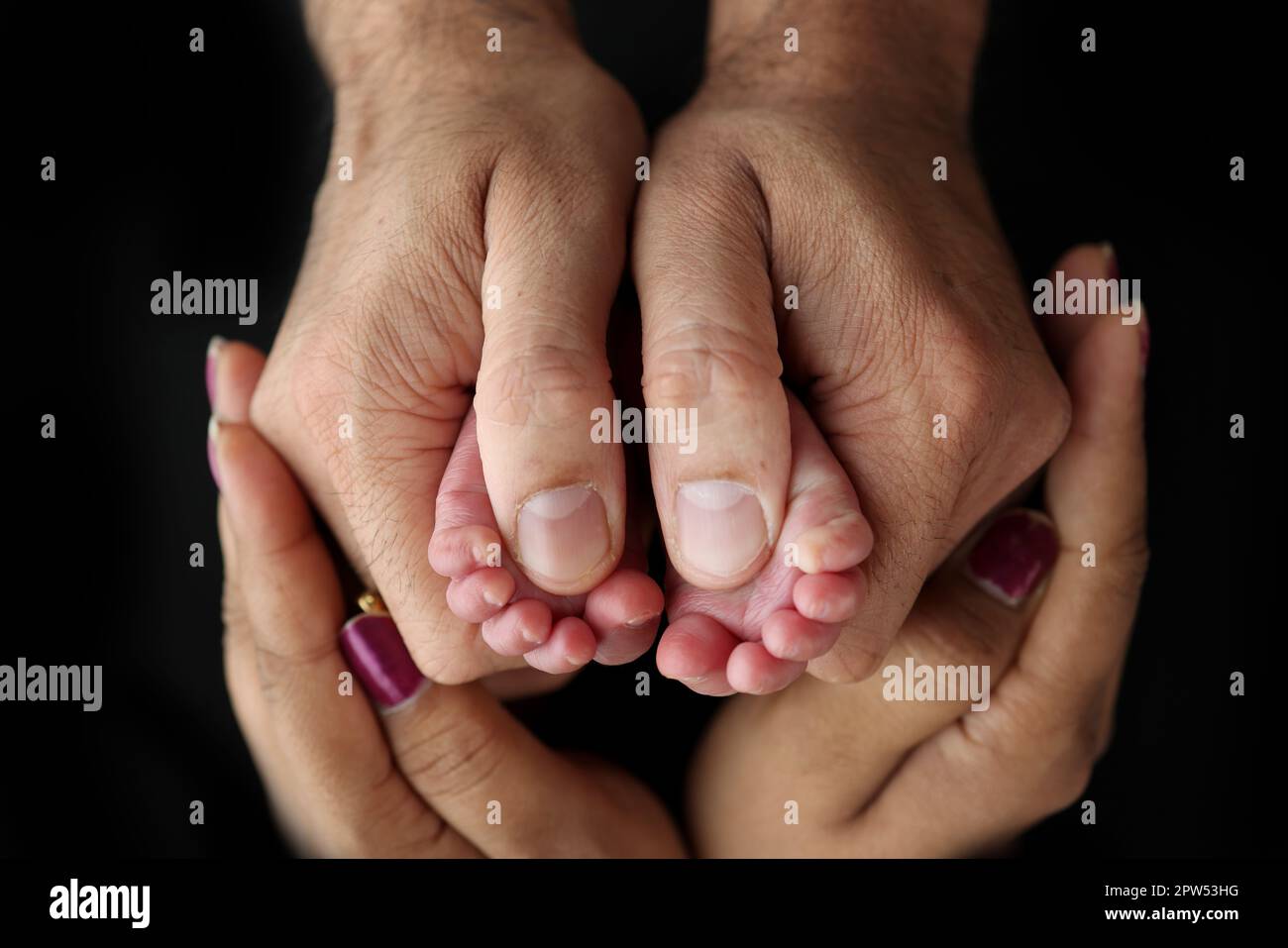 Feet of newborn baby in the hands of parents. Happy Family oncept. Mum ...