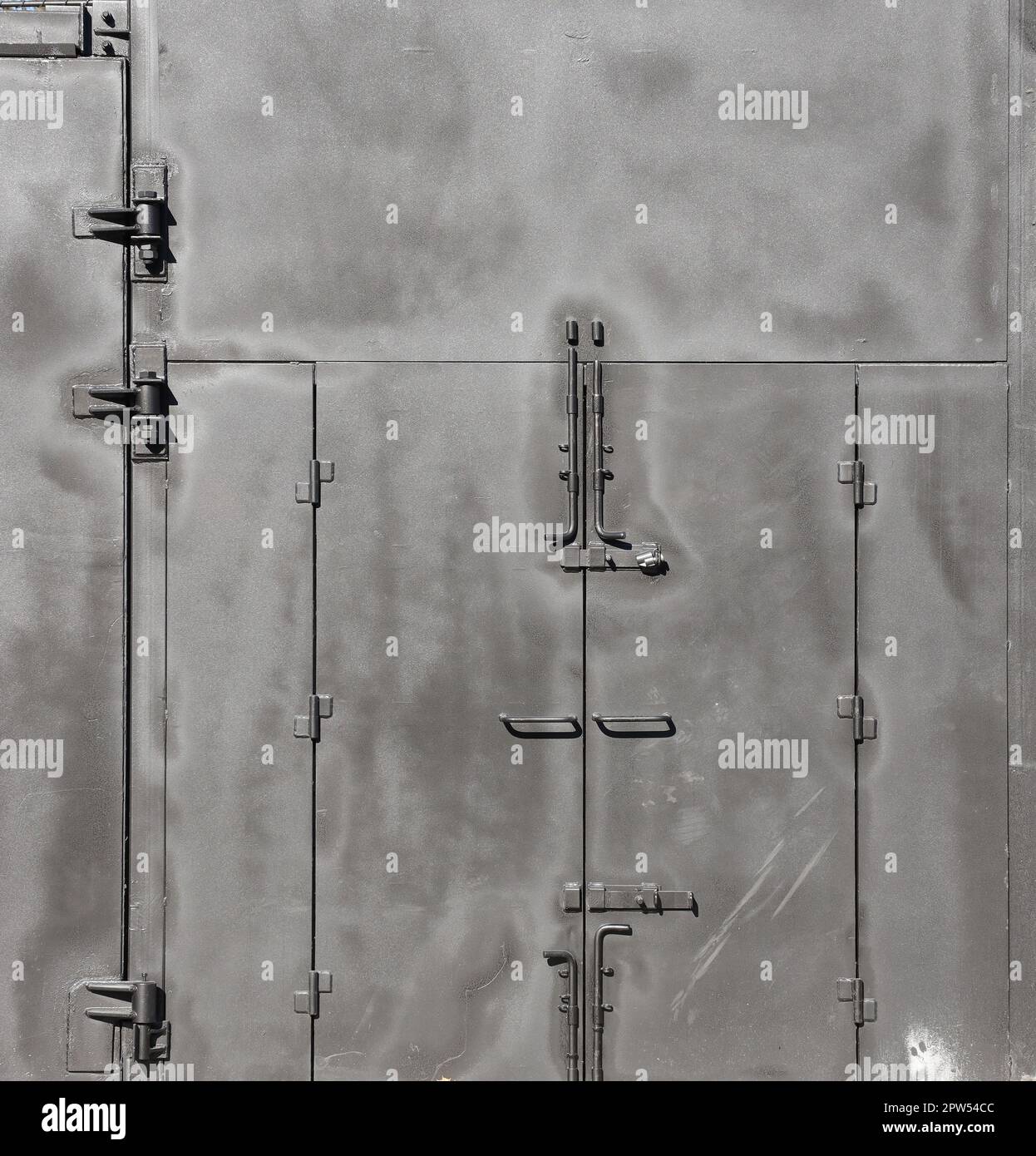 Black painted garage gates with door under the sunlight. Background ...