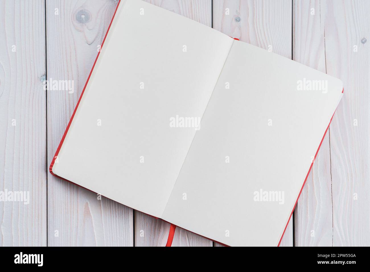 Red diary, text book with white paper pages on wooden table background ...