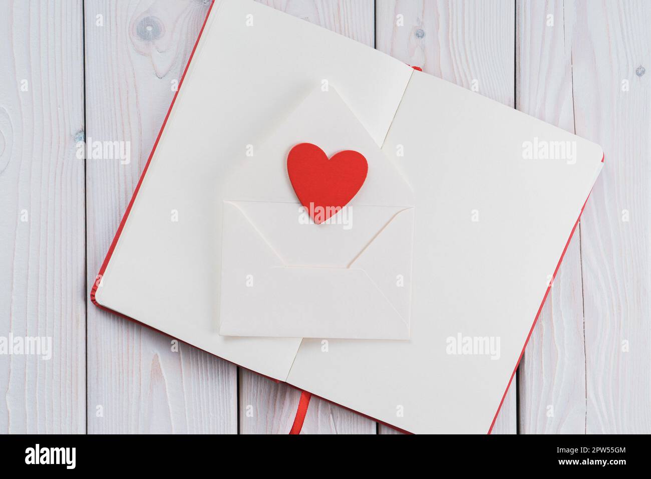 Red diary book with white paper with red heart in craft envelope on ...